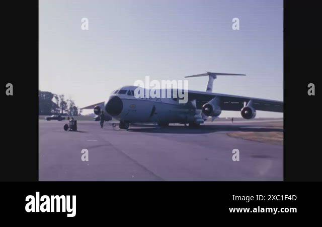 1973 - A USAF airman walks his unit's dog mascot up to a C-5A Stock ...