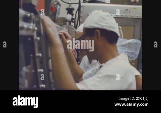 1969 - NASA scientists observe each other working within a vacuum ...