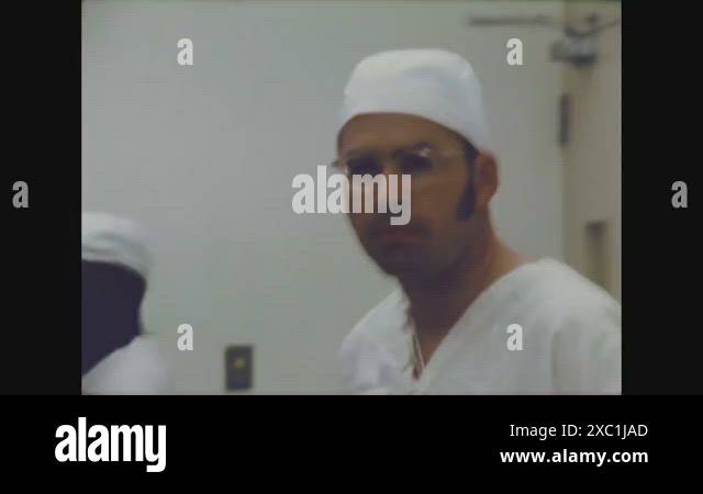 1969 - NASA scientists handle a sample case in a vacuum chamber and ...