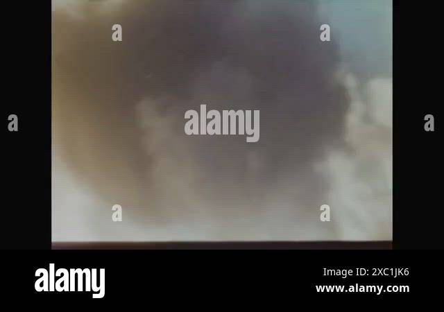 1943 - A US Navy aircraft carrier sails along in a billow of thick ...