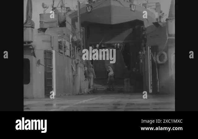 1944 - US Army trucks are driven down the ramp of an LST for the D-Day ...