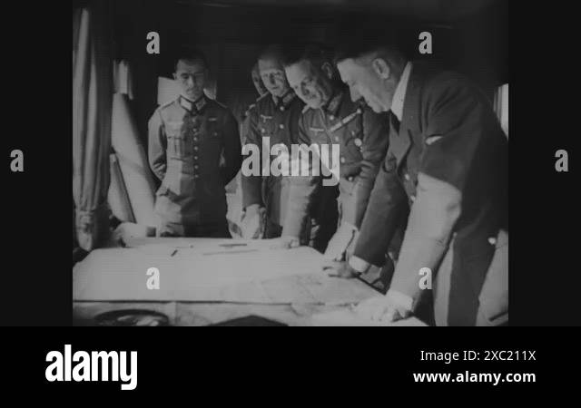 1939 - Adolf Hitler salutes his troops as they march past, and the ...