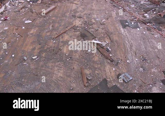 Tilt up from a debris covered floor to show the exposed beams and ...