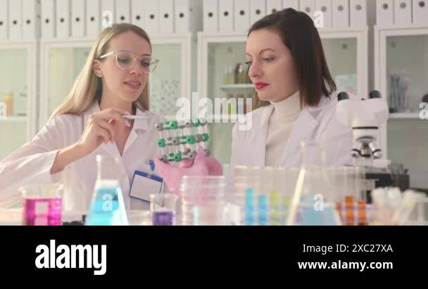 Women scientists observe molecular model in chemical lab. Chemists ...