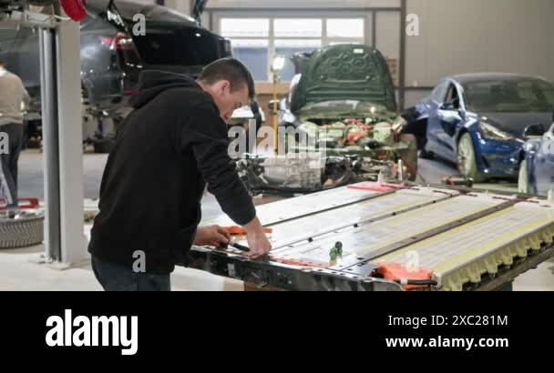 Male technician repairing a high-capacity lithium-ion battery module ...