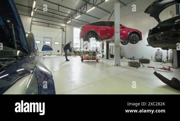 Mechanics performing maintenance and repair on electric vehicles in a ...
