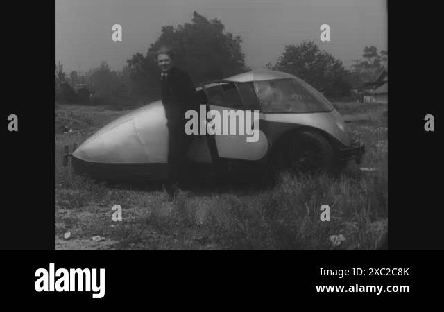 1936 - A bug-like car with a motor in the back is driven (narrated in ...