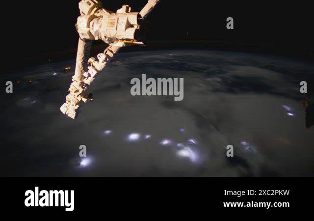 The International Space Station flies over the earth at night with storms and lightning strikes ...