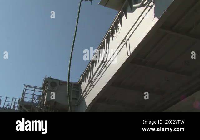 Sailors aboard an aircraft carrier practice rope exercises on deck ...