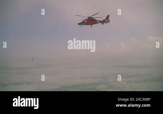 An airman descends from a Coast Guard search and rescue helicopter in a ...