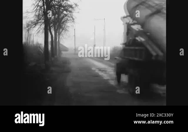 1945 - A US Army truck convoy carries pontoon boats down a German road ...