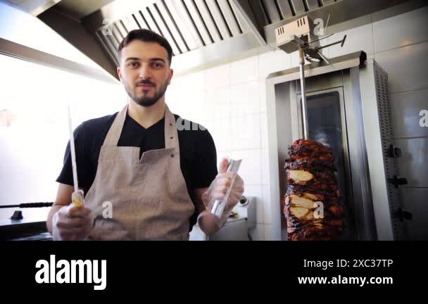 Kebab maker standing on kitchen in street food restaurant. Chef making ...