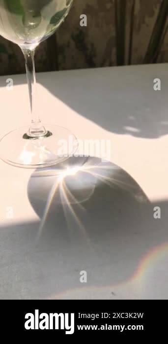 Sunlight Refracting Through Wine Glass. A wine glass filled with clear ...