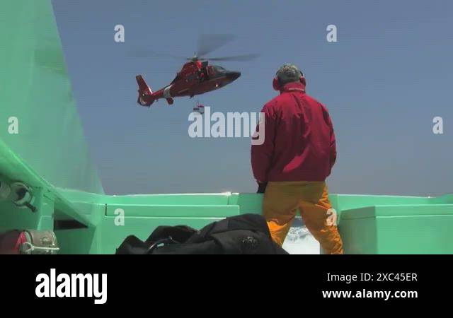 The U.S. Coast Guard conducts a practice rescue hoist maneuver with ...