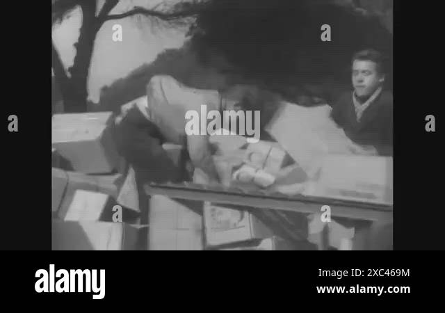 1944 - Italian workers check and push ration boxes along conveyers at a ...