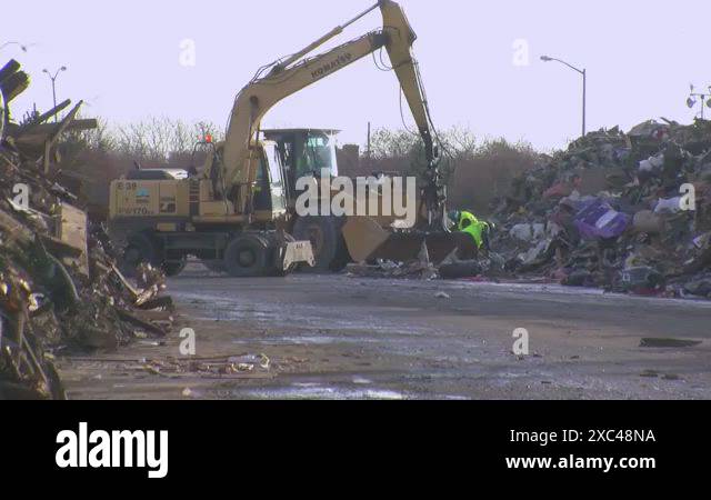 Huge piles of garbage and rubble are bulldozed in a junkyard following ...