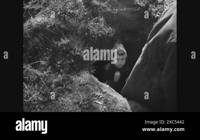1945 - German children and a woman come out of an underground hiding ...