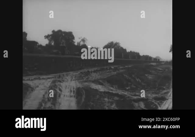 1945 - A convoy of American army jeeps and trucks pulling artillery ...