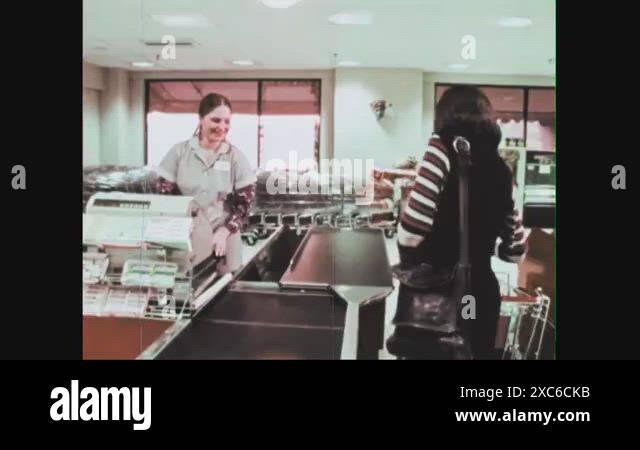 USA - 1976 - A cashier demonstrates how to efficiently ring up items ...