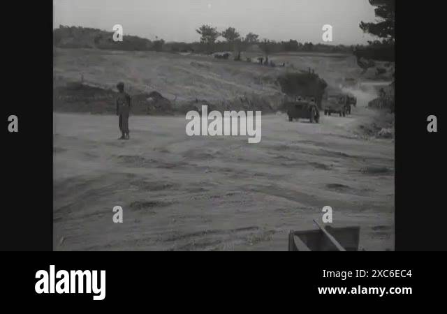 1945 - Army traffic passes an intersection of dirt roads on Okinawa ...