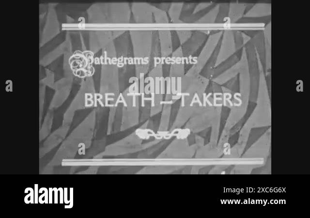 USA - 1920s - A daredevil in a straitjacket hangs outside of a flying ...