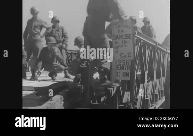 1945 - Soldiers hang a sign on a newly built bridge and play ...