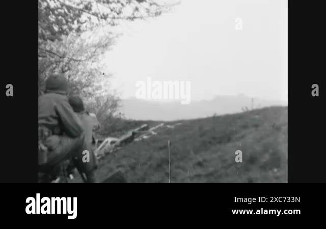 1945 - Soldiers fire machine guns and howitzers on a hillside in ...