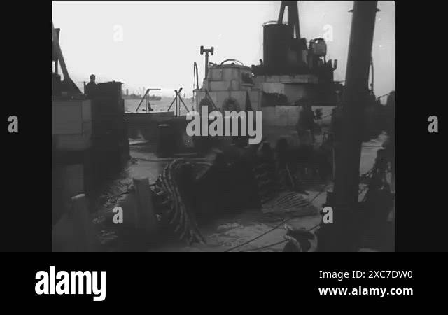 NORMANDY - 1944 - A US Army soldier uses a rope to cross from one ship ...