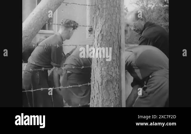 GERMANY - 1947 - German prisoners carry a log through a US Army camp ...