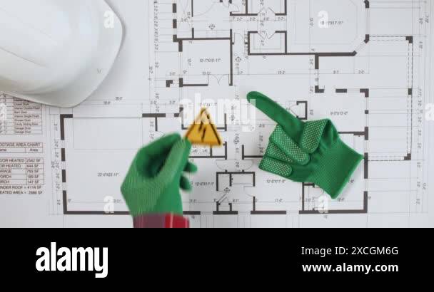 Technician puts electrical warning sign between helmet and pointer of ...