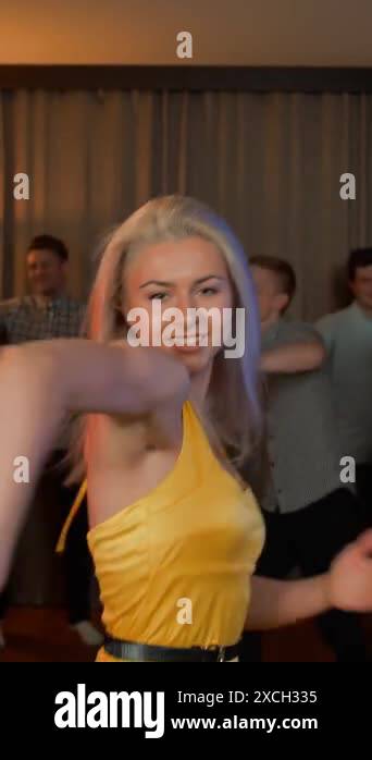 Woman dancing at party. Pretty cheerful blond girl in yellow dress ...