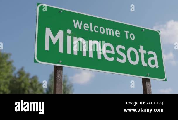 Driving By A Welcome To Minnesota Green Road Sign Against a Blue Sky ...