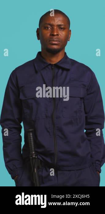 Vertical video Smiling security guard saluting people during ...