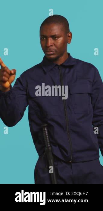 Vertical video Portrait of security agent pointing finger at people ...