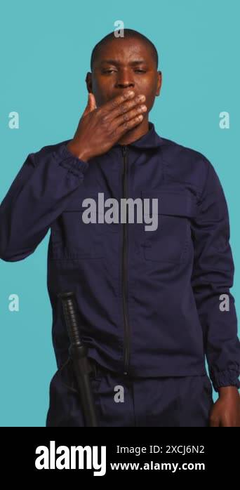 Vertical video Tired security guard yawning while being tasked with ...