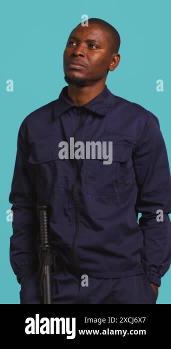 Vertical video Security guard doing thinking hand gesture during ...