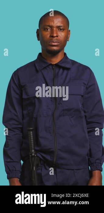 Vertical video Security guard in threatening pose, tasked with ...