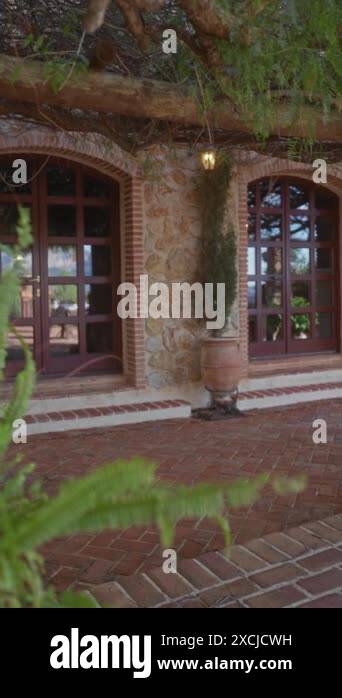 Mediterranean-style facade with terracotta pots, brick pavement, and ...