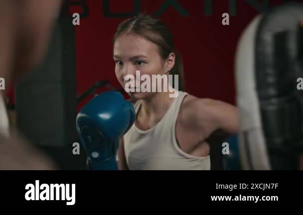 Medium close-up over-shoulder shot of determined young petite Asian ...