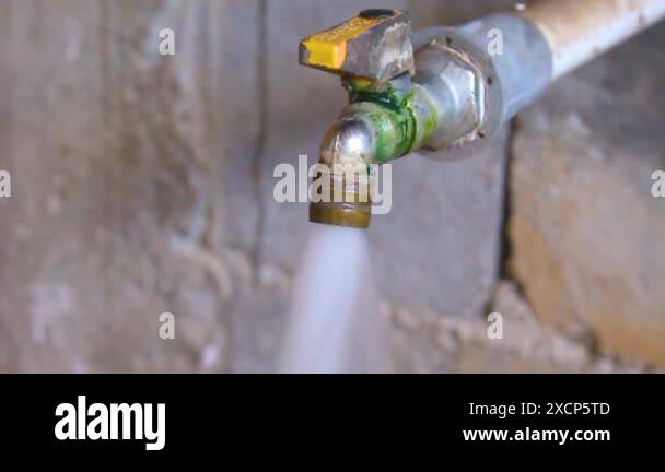 Women closes the open water tap. Close-up of a woman's hand closing a ...