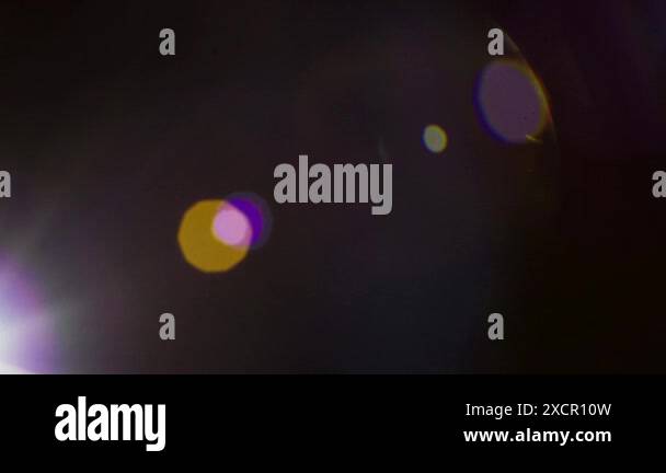 Several lens flares are scattered across a dark background. A bright ...