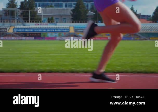 Young woman sprinting on track at the stadium. Female athlete running ...