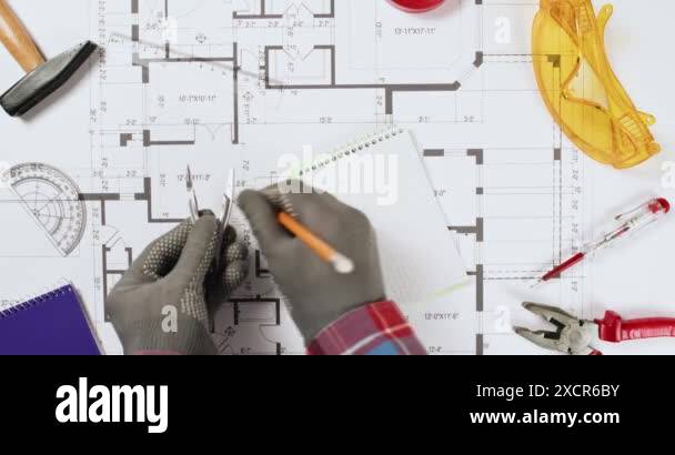 Worker checks floor plan and writes numbers on apartment drawing upper ...