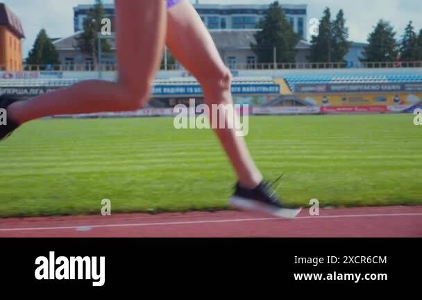 Young woman sprinting on track at the stadium. Female athlete running ...