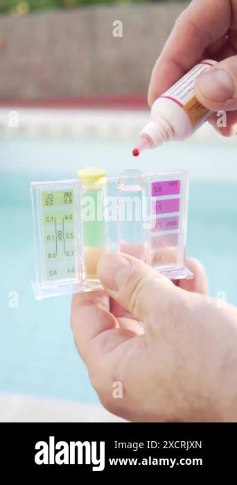 The hand of the maintenance person with a test-tube, pouring drops to ...