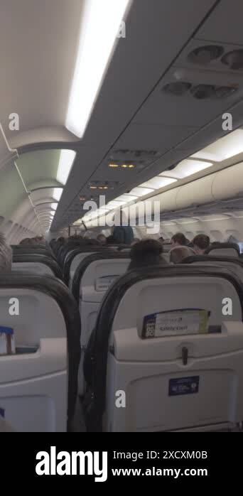 Vertical Wide footage of inside a flight with people sitting on ...