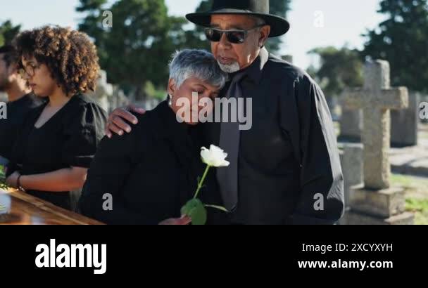 Graveyard, mature man and woman hug at funeral, memorial service or ...