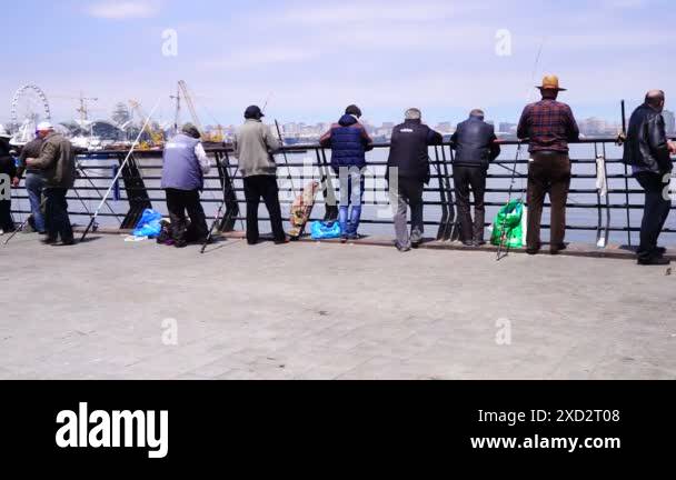 Fishermen catch fish on the Wharf of the Caspian sea.The City Of Baku ...