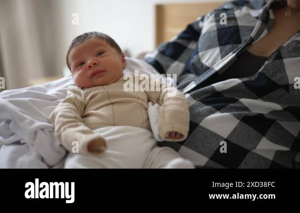 Newborn baby resting peacefully on mother's lap, serene expression and ...