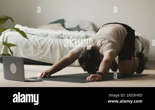 Yoga online. Young man practicing child pose position for back ...